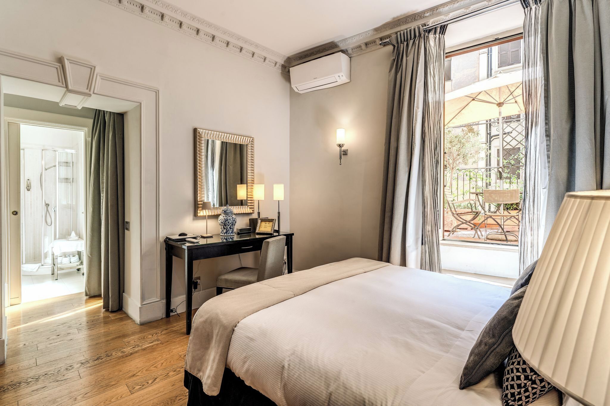 Quarto de hotel com cama, escrivaninha e vista para o exterior.