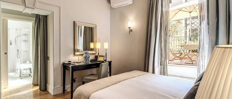Quarto de hotel com cama, escrivaninha e vista para o exterior.