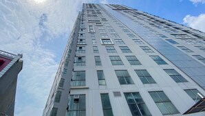 Um edifício alto e moderno com uma grade de janelas e fachada de vidro refletivo.