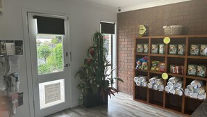 Um quarto com piso de madeira, parede de tijolos e uma prateleira com toalhas enroladas.