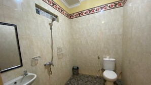 Casa de banho com lavatório, sanita e chuveiro.