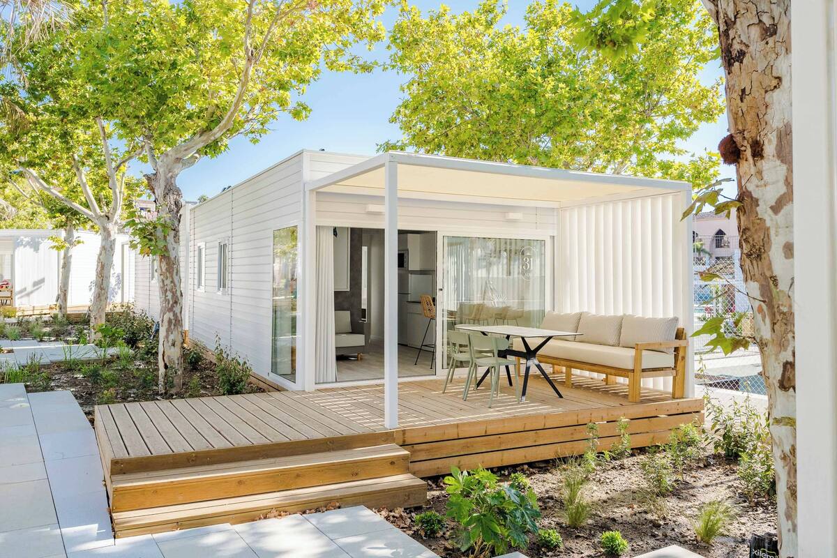 Uma casa móvel moderna, térrea, com varanda, área de estar externa e jardim.