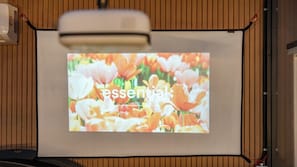 Tela de projeção com a palavra 'essential' sobre um fundo floral.