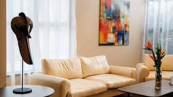 Uma sala de estar moderna com um sofá, uma mesa de centro e uma escultura decorativa.