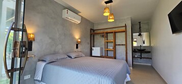 Quarto com cama, luminárias de cabeceira, ar condicionado e televisão.