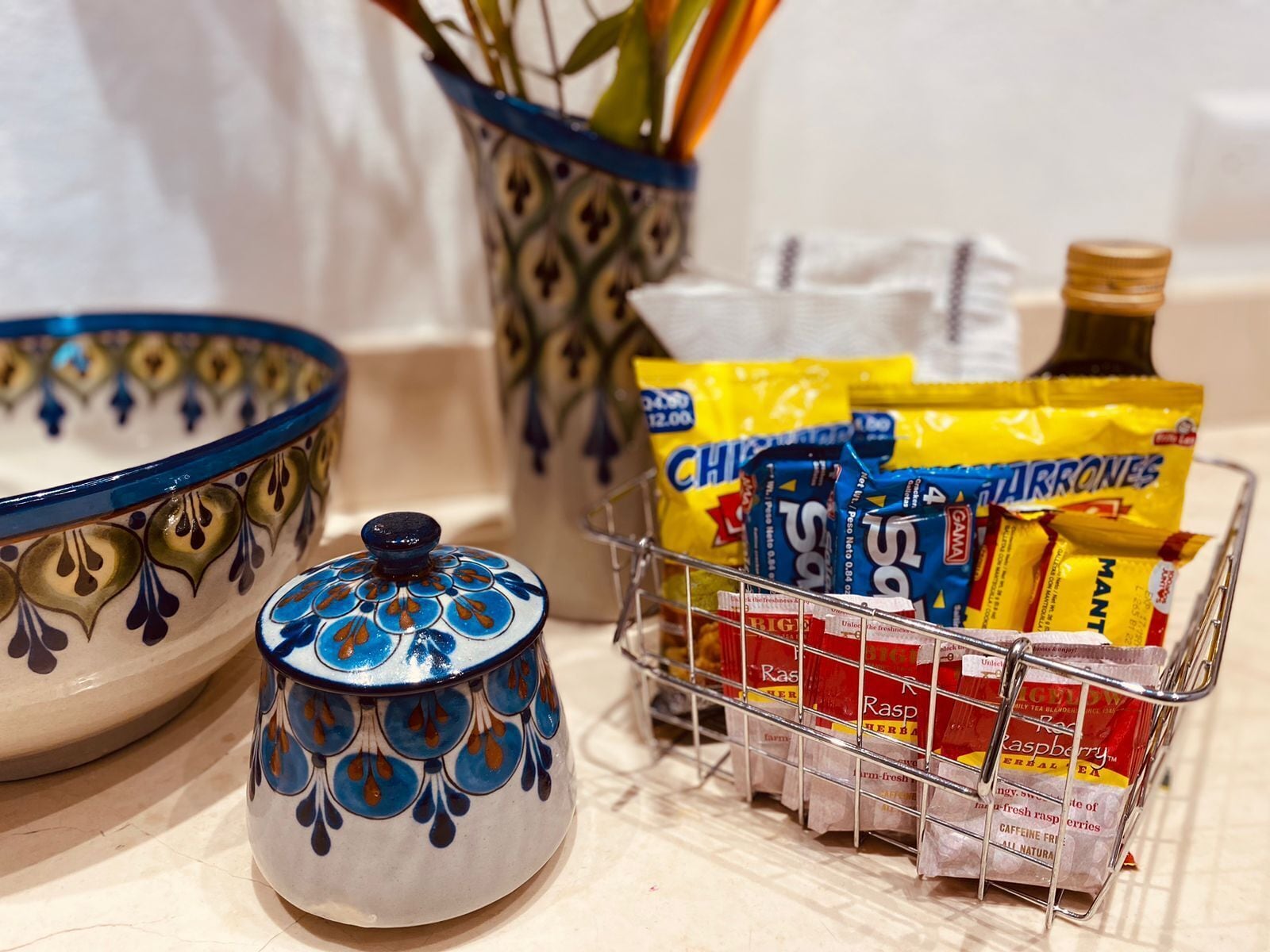 Uma bancada de cozinha com tigelas decorativas, um porta-temperos e lanches embalados.