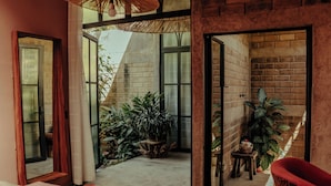 Quarto com parede de tijolos, janela e planta.