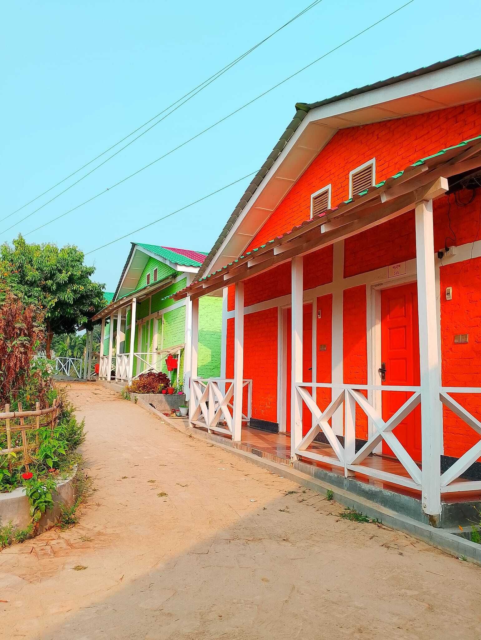 Uma fileira de edifícios coloridos com um caminho de terra que leva a eles.