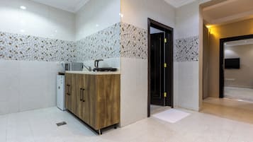 Apartamento luxo, 2 quartos | Cozinha privada | Frigobar, micro-ondas, chaleira elétrica, mesas de jantar