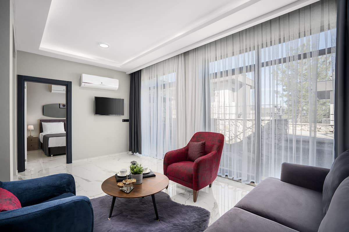 Uma sala de estar moderna com um sofá, uma poltrona e uma mesa de centro.