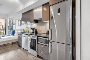 Uma cozinha moderna com eletrodomésticos de aço inoxidável, forno embutido e uma geladeira grande.