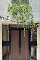 Uma entrada gradeada com porta de madeira e uma placa indicando "26 The Urban Westlake Apartment".