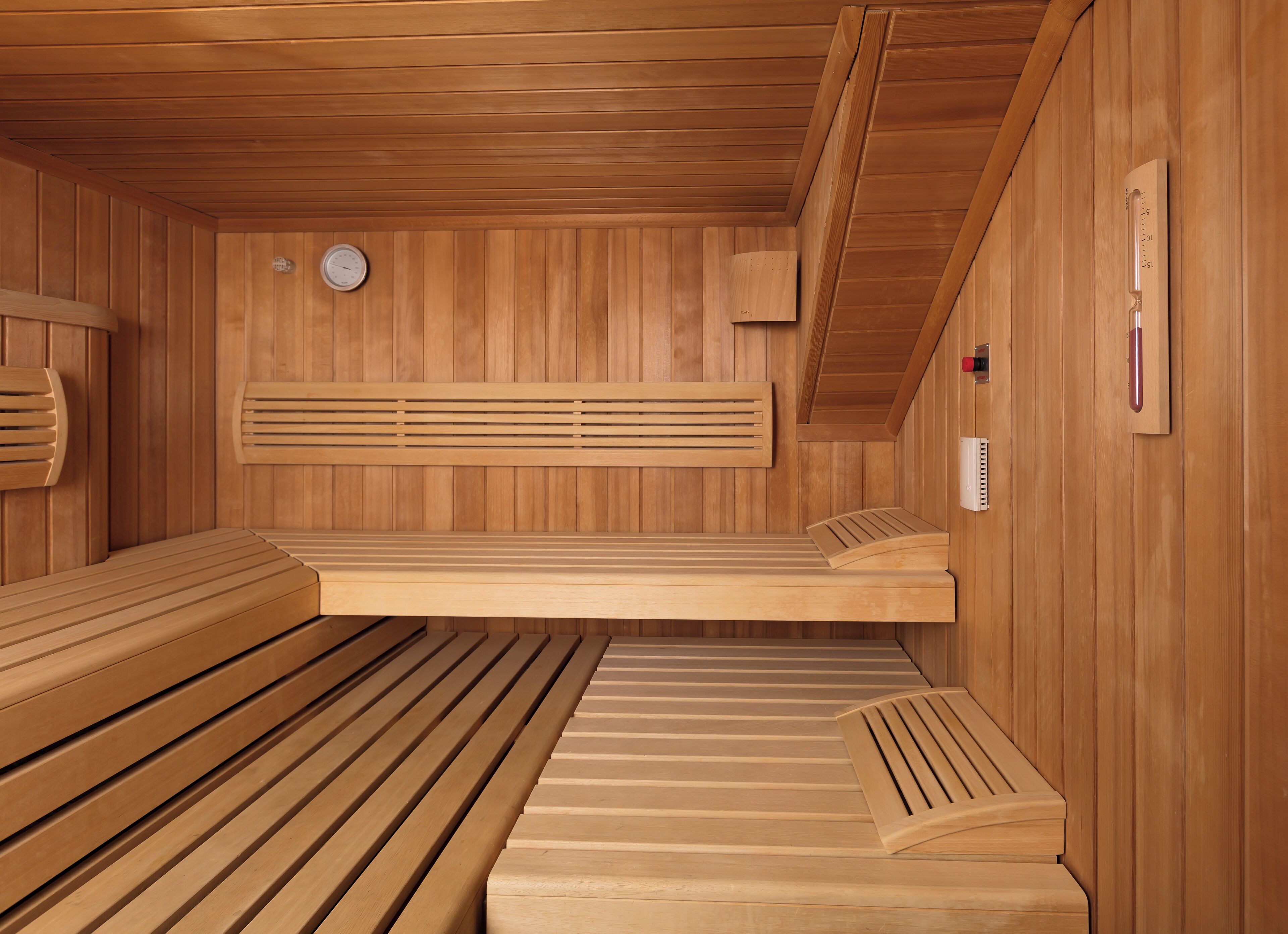 Uma sauna com bancos de madeira e um banco ripado.