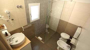 Quarto quádruplo clássico, vista para a cidade | Banheiro | Chuveiro, produtos de toalete grátis, secador de cabelo, bidê