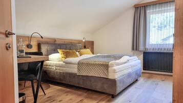 Quarto com cama, escrivaninha e cadeira.