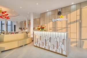 Uma área de recepção com design moderno, com balcão de atendimento, sofá e relógio fixado na parede.