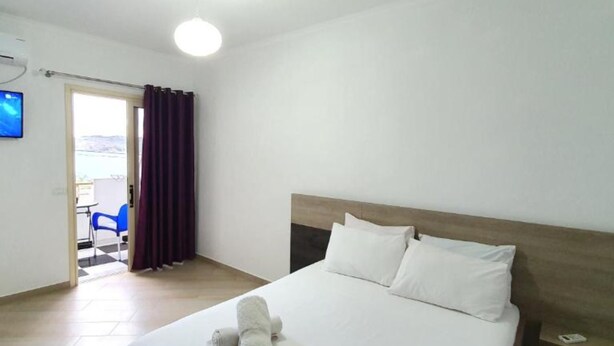 Quarto de hotel com cama, televisão e vista para o exterior.