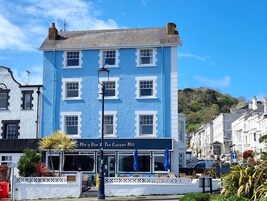 Um edifício azul com uma placa que diz 'Min y Don & The Copper Mill'.