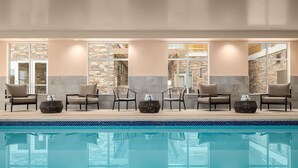 Uma área à beira da piscina com assentos e vista para a piscina.