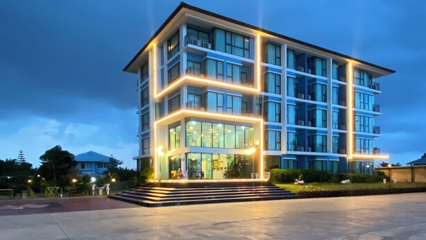 Um edifício moderno com fachada de vidro e entrada bem iluminada.