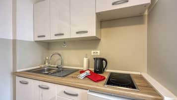 Um frigorífico, uma placa de cozinha, uma chaleira elétrica