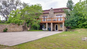 Uma casa de pedra com varanda, porta de entrada e um pequeno espaço de estar ao ar livre.