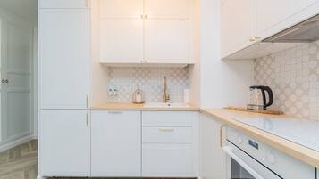 Apartamento Deluxe | Cozinha privada | Um frigorífico, um forno, uma placa de cozinha