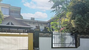 Área residencial murada com um muro branco e portão amarelo.