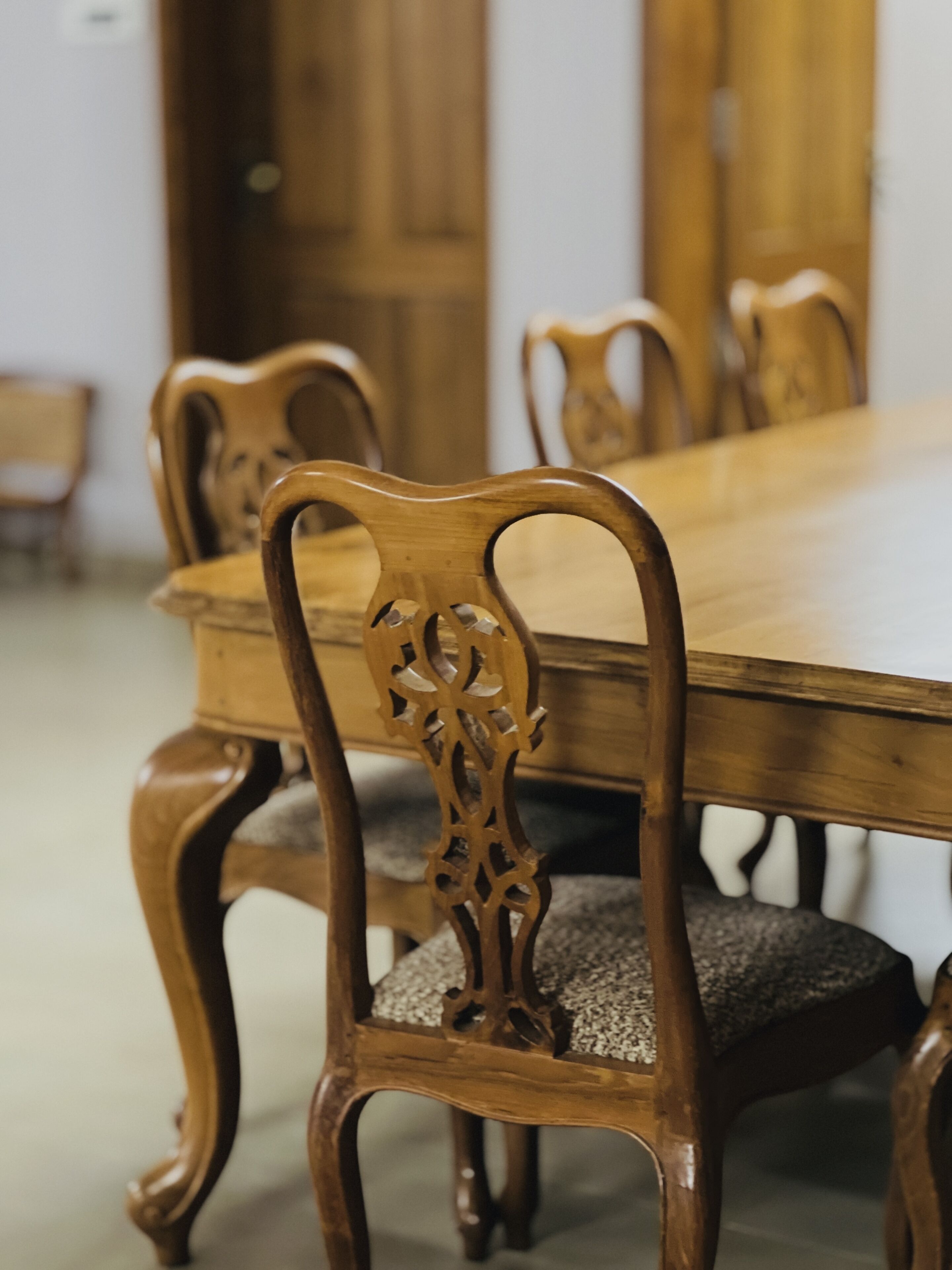 Uma mesa de jantar de madeira com cadeiras decoradas.