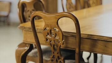 Uma mesa de jantar de madeira com cadeiras decoradas.