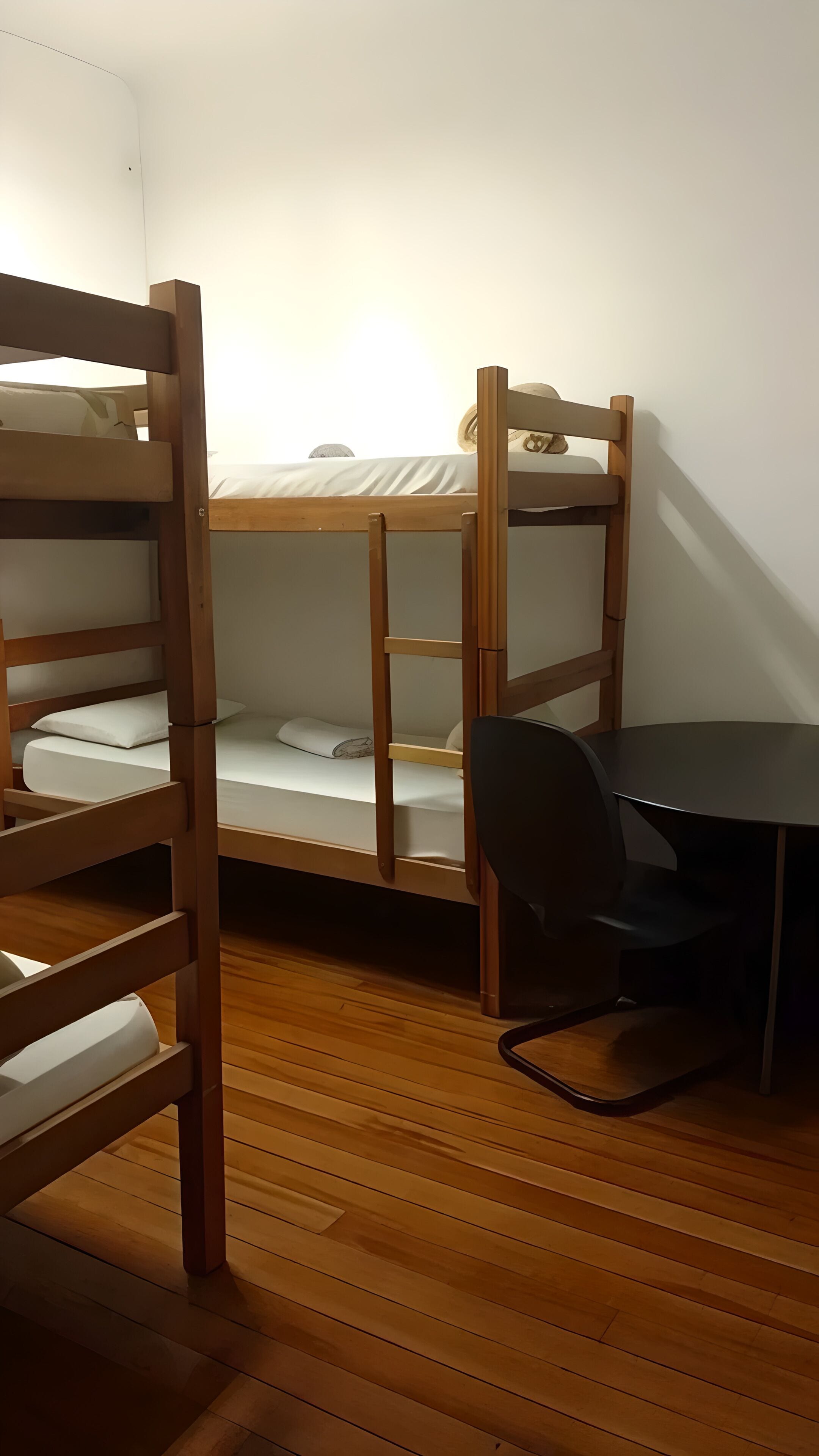 Quarto com beliche, escrivaninha e cadeira.