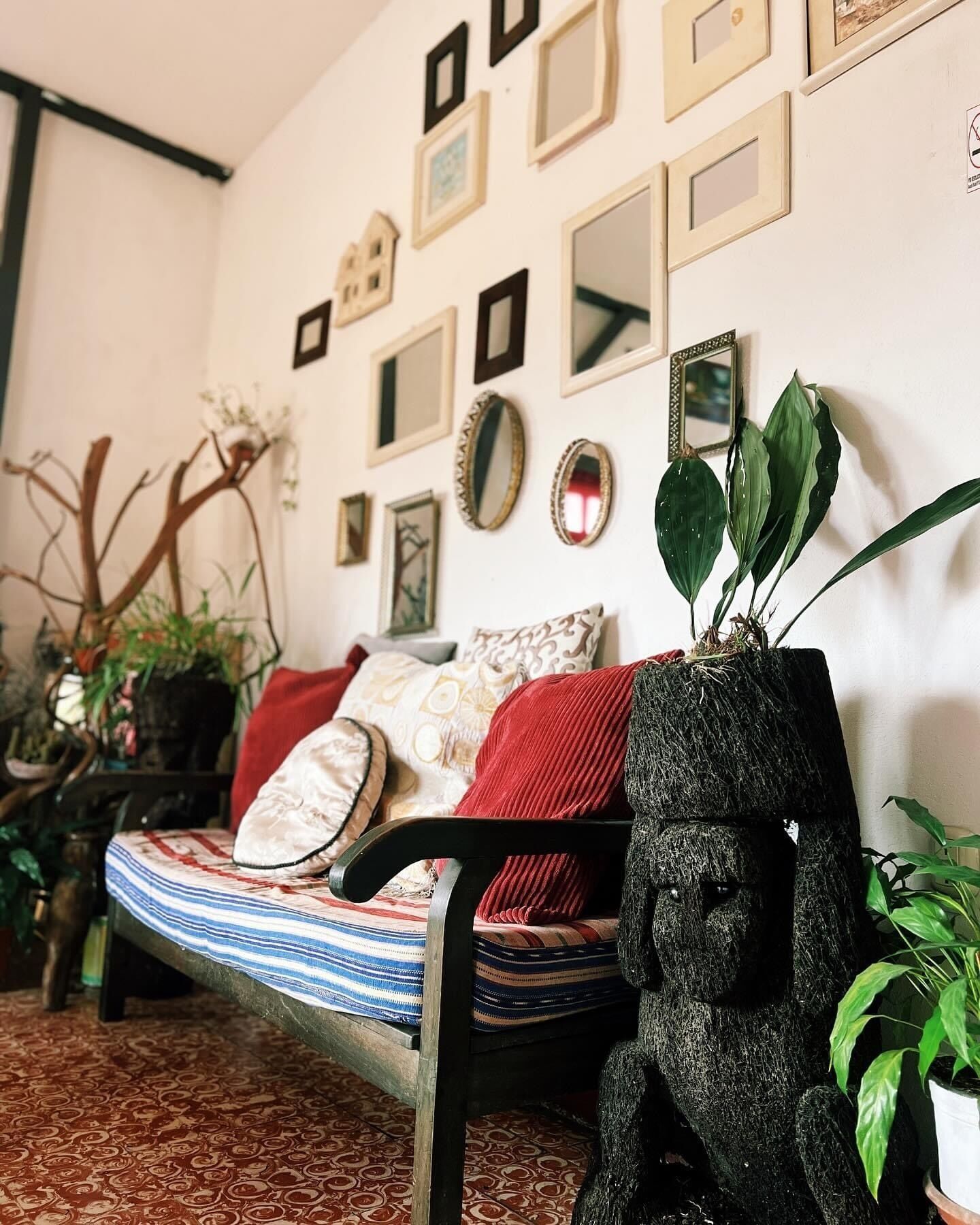 Um quarto aconchegante com um sofá, um exclusivo encosto de cabeça de pedra e diversas fotos emolduradas na parede.
