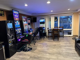 Quarto com máquinas de jogos, área de refeições e vista para a rua.