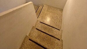 Uma escadaria moderna com um design circular único na parede, um luminário e piso texturizado.