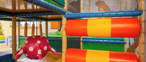 Uma área de recreação com estruturas coloridas e um cercado de rede.