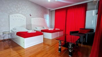 Quarto Triplo | Minibar, ferro/tábua de engomar, Wi-fi grátis, roupa de cama fornecida