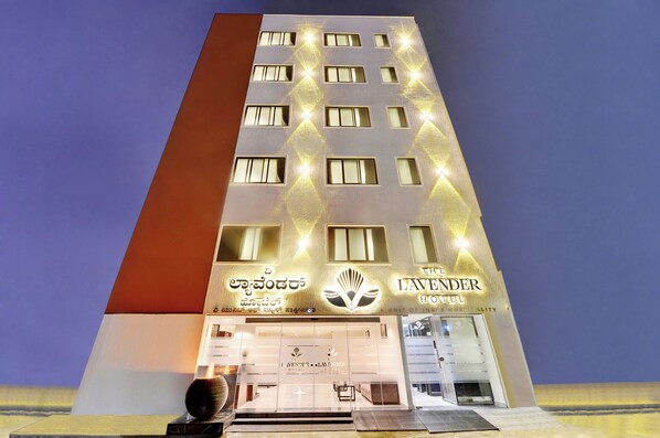 Hotel com fachada moderna, várias janelas e um logotipo em destaque.