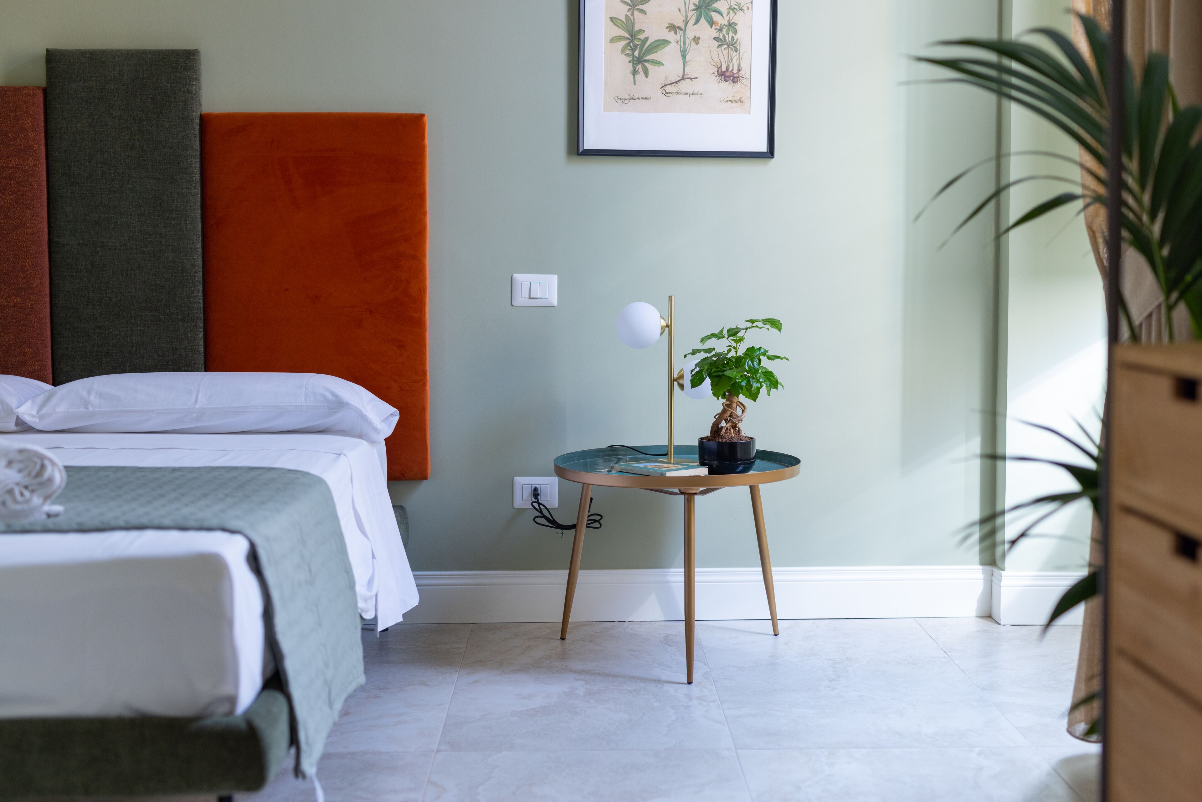 Um quarto com uma cama, mesa de cabeceira e prateleira na parede.