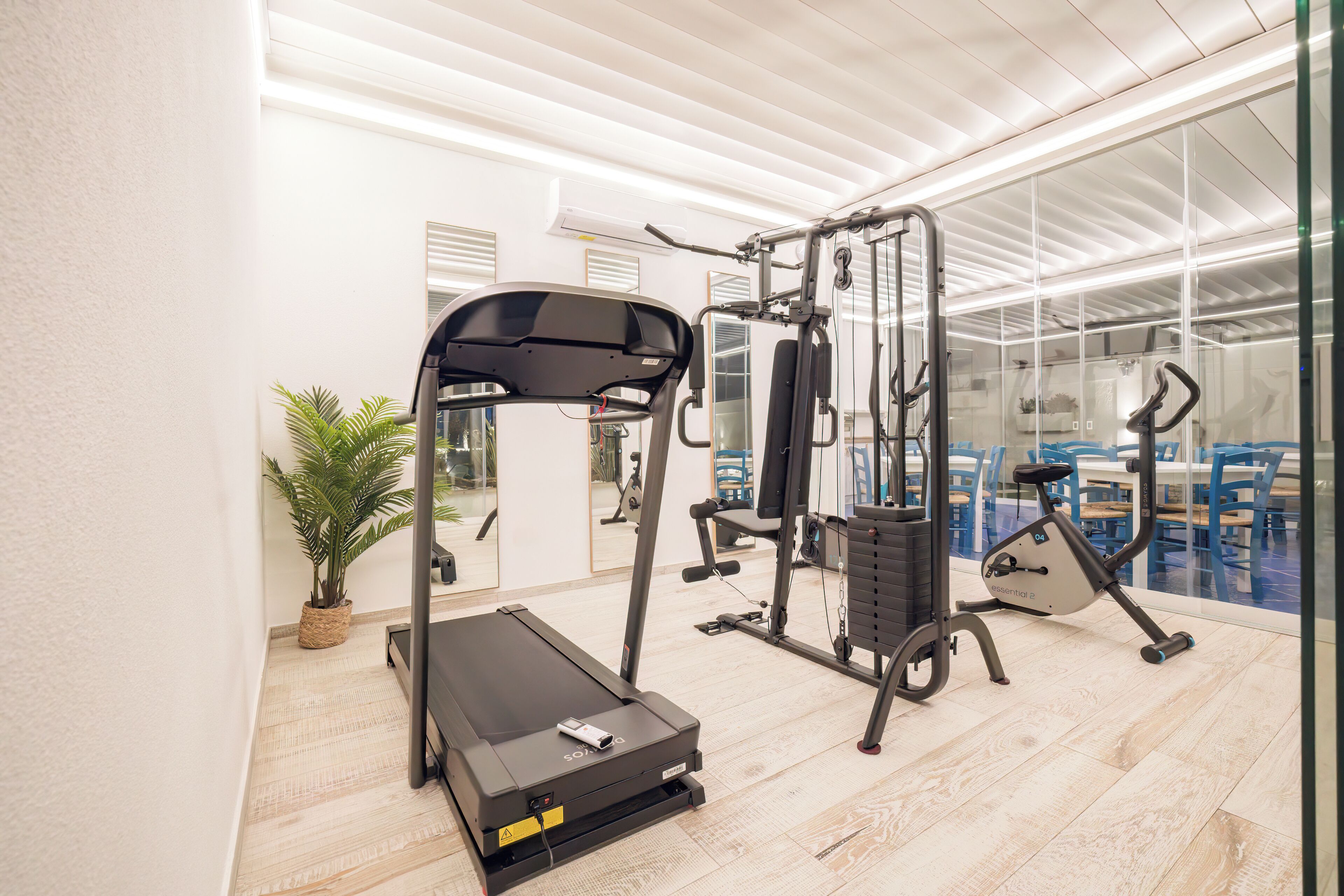 Academia moderna com equipamentos de cardio, máquinas de peso e esteira.