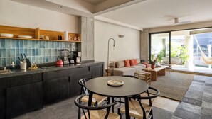 Uma cozinha moderna com armários escuros, uma ilha central e um espaço de refeições com uma mesa redonda e cadeiras.