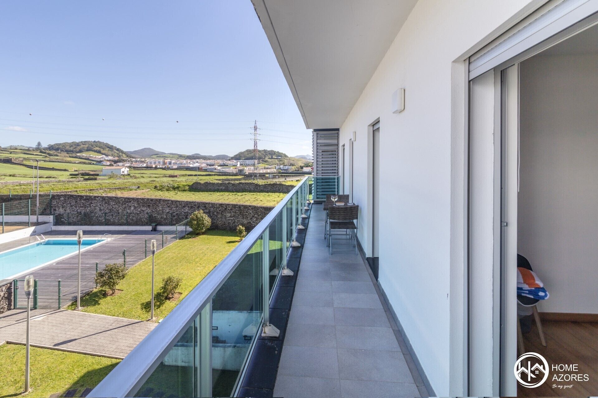 Uma varanda com piscina, vista desobstruída do campo e design arquitetônico moderno.