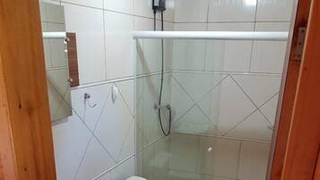Um banheiro com vaso sanitário, pia e chuveiro.
