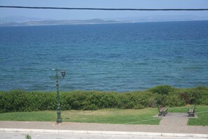Vista costeira com um lampião e bancos ao longo de um caminho.