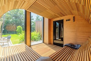 Interior moderno de madeira com uma grande porta de vidro que dá para um jardim.