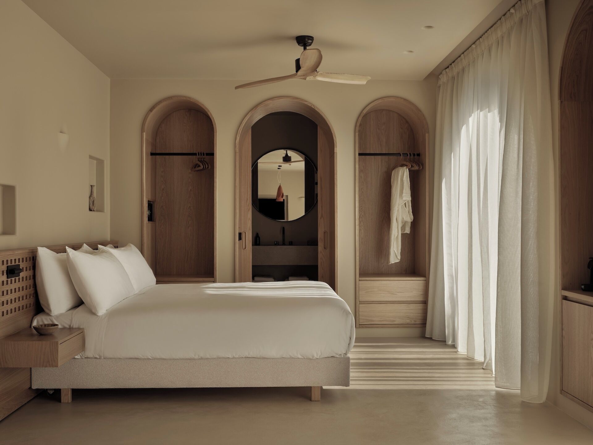 Um quarto moderno com uma cama grande, um closet espaçoso e um ventilador de teto.