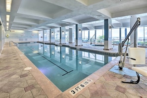 Piscina interior com divisórias demarcadas, uma cadeira de salva-vidas e chão azulejado com indicação de profundidade de 1,07 metros.