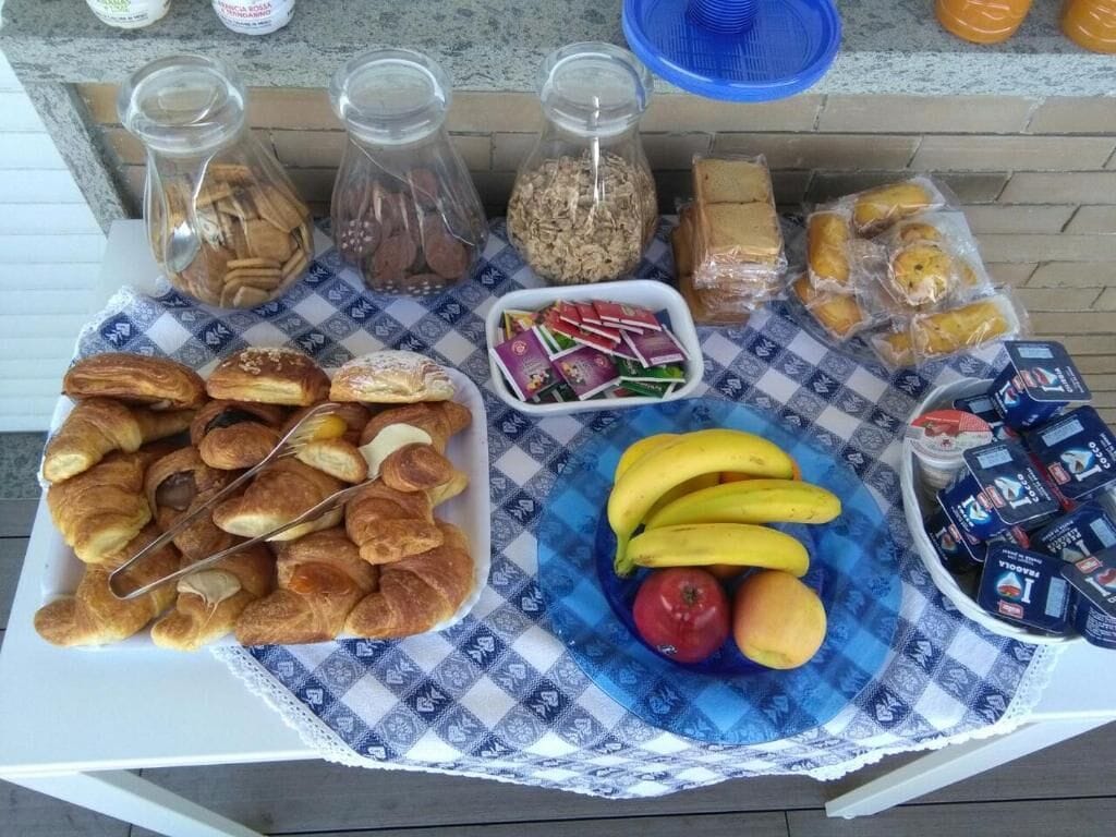 Uma mesa com doces, frutas e lanches embalados.