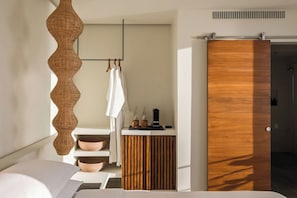 Uma casa de banho moderna com toucador de madeira, candeeiro pendente e porta de correr.