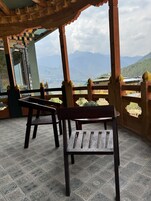 Uma varanda de madeira com vista para montanhas.