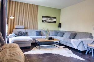 Uma sala de estar moderna com um sofá seccional, uma mesa de centro e um tapete.